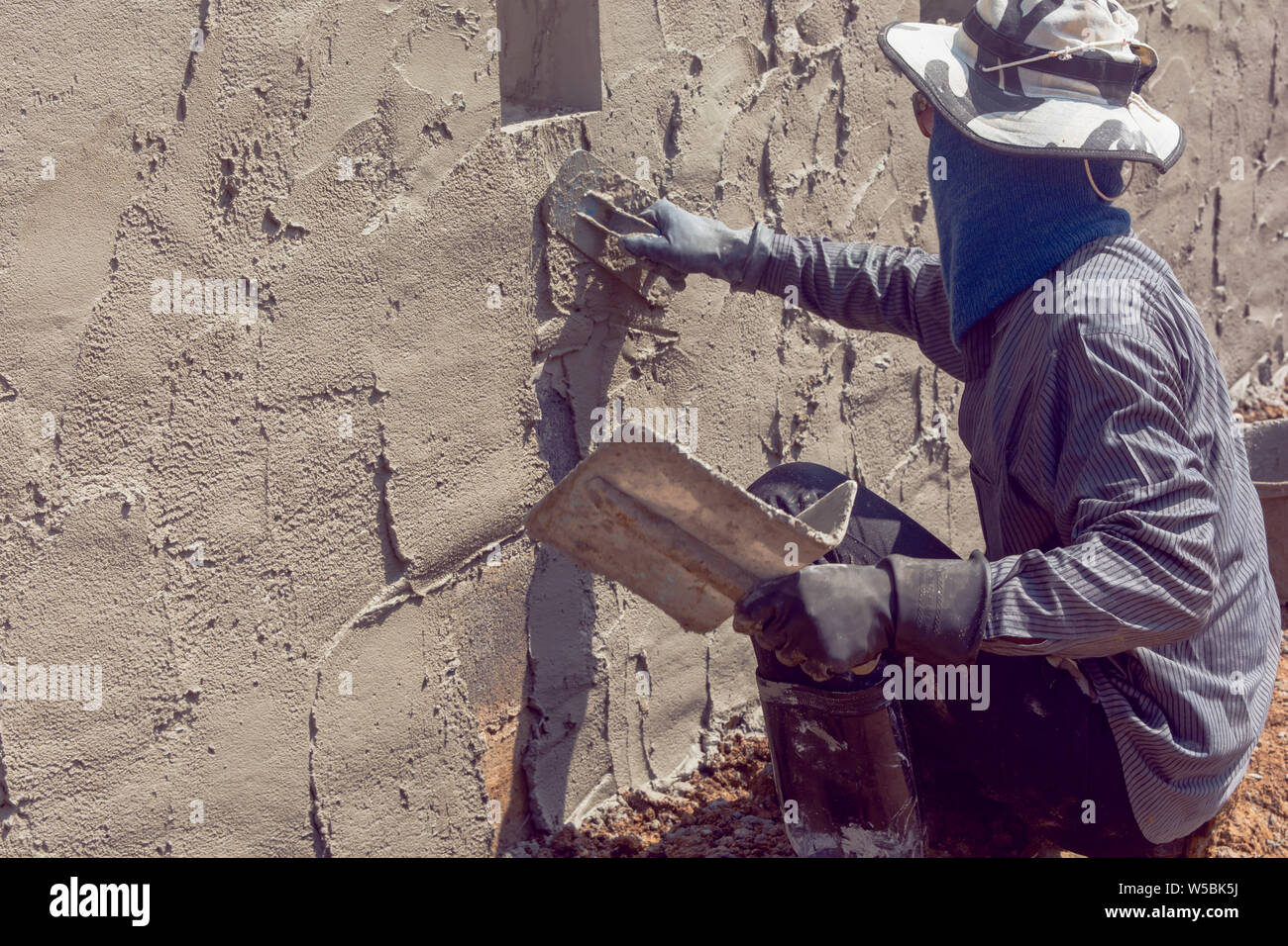 Construction workers plastering building wall using cement plaster ...
