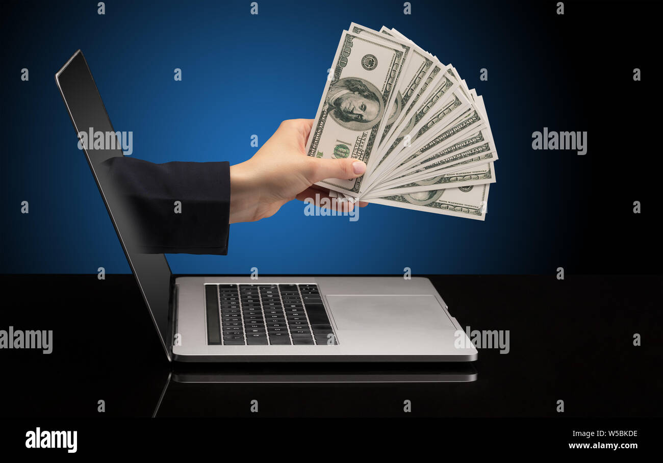 Hand with money coming out of a laptop with sparkling effects Stock ...