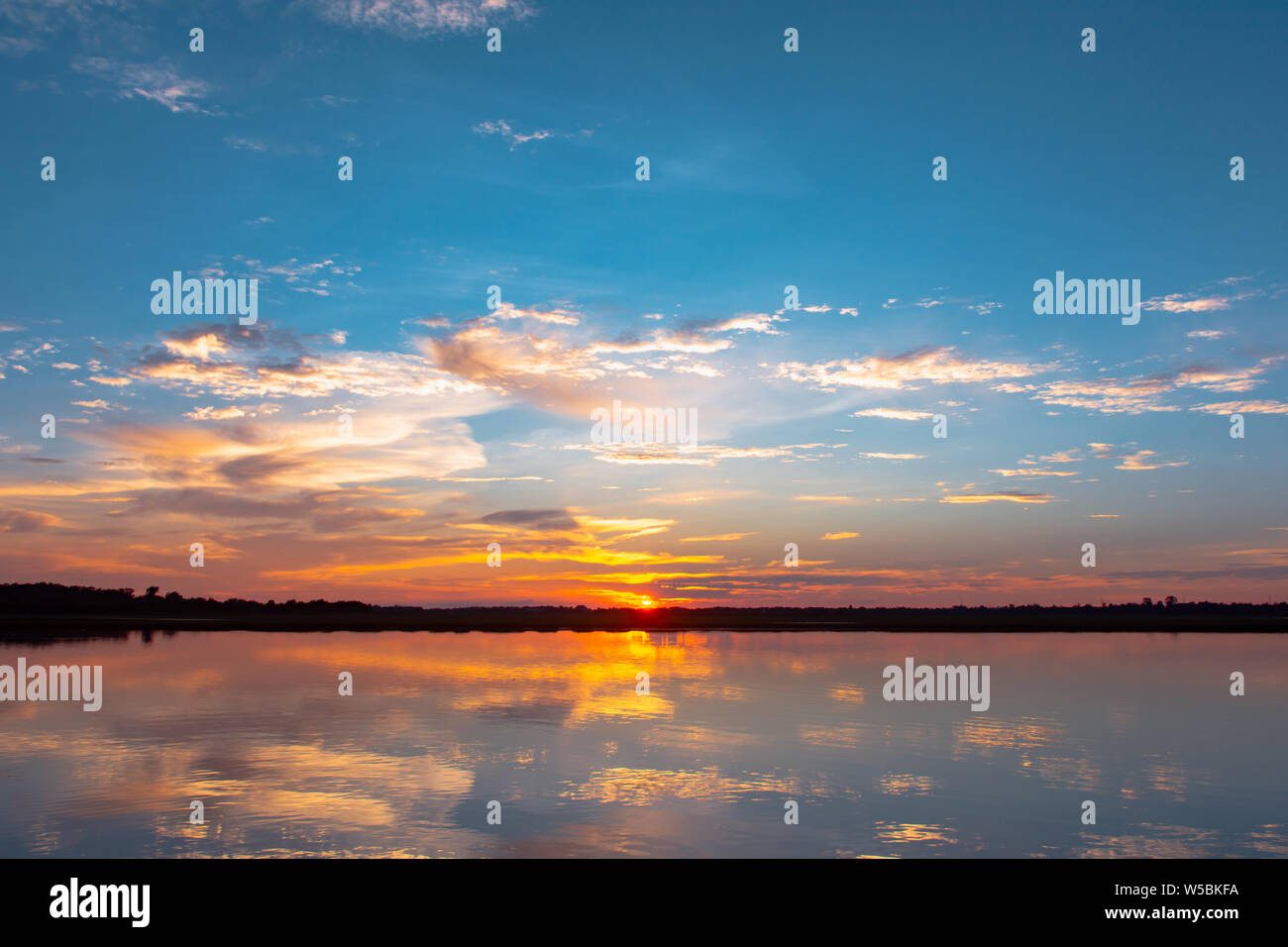 Sunset reflection lagoon. beautiful sunset behind the clouds and blue ... Sunset reflection lagoon. beautiful sunset behind the clouds and blue ...