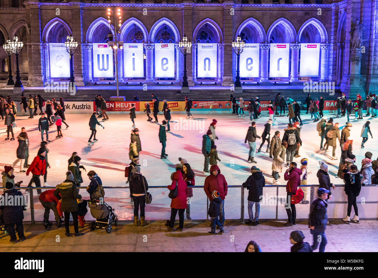 Crowd of people skating in front of Rathausplatz which is transformed ...