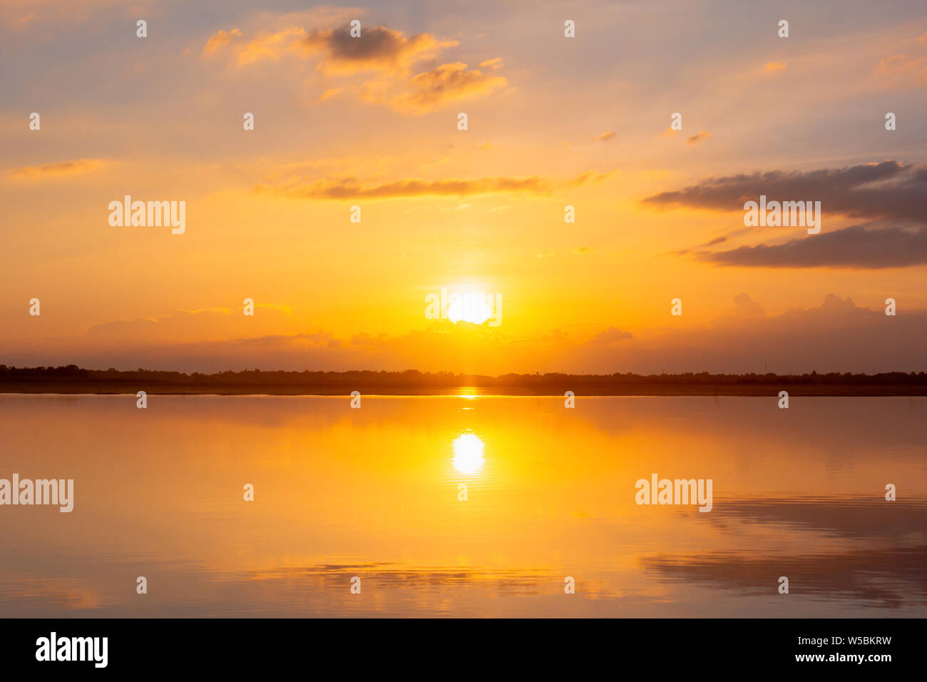 Sunset reflection lagoon. beautiful sunset behind the clouds and blue ... Sunset reflection lagoon. beautiful sunset behind the clouds and blue ...