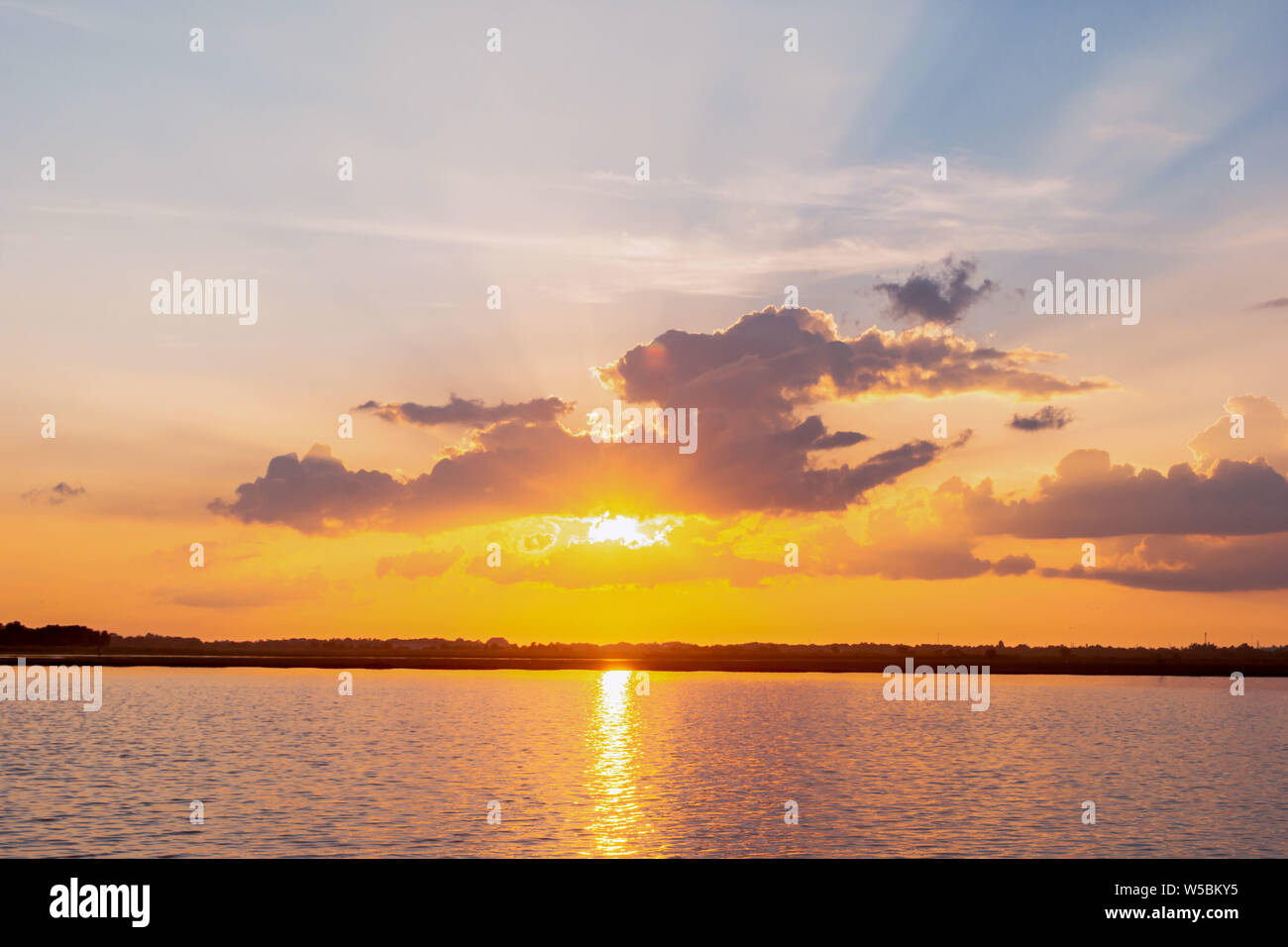 Sunset reflection lagoon. beautiful sunset behind the clouds and blue ... Sunset reflection lagoon. beautiful sunset behind the clouds and blue ...