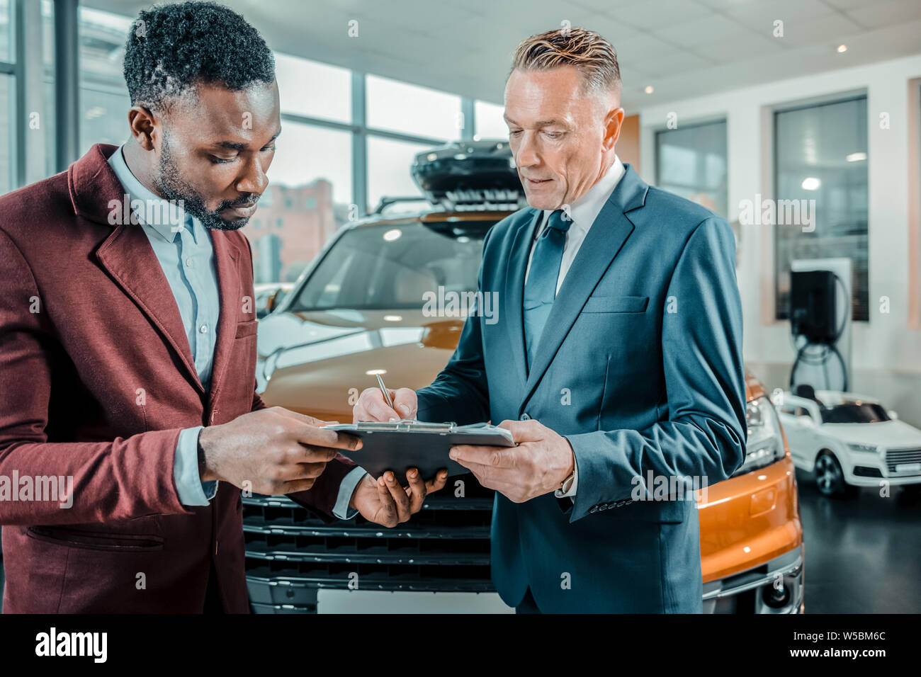 Businessman signing a contract buying a car Stock Photo - Alamy