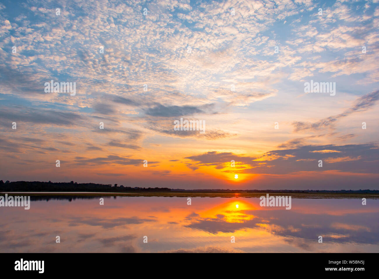 Sunset reflection lagoon. beautiful sunset behind the clouds and blue ... Sunset reflection lagoon. beautiful sunset behind the clouds and blue ...
