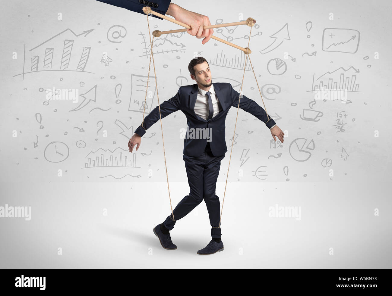 Puppet employee controlled by a big hand with documents and staffs ...