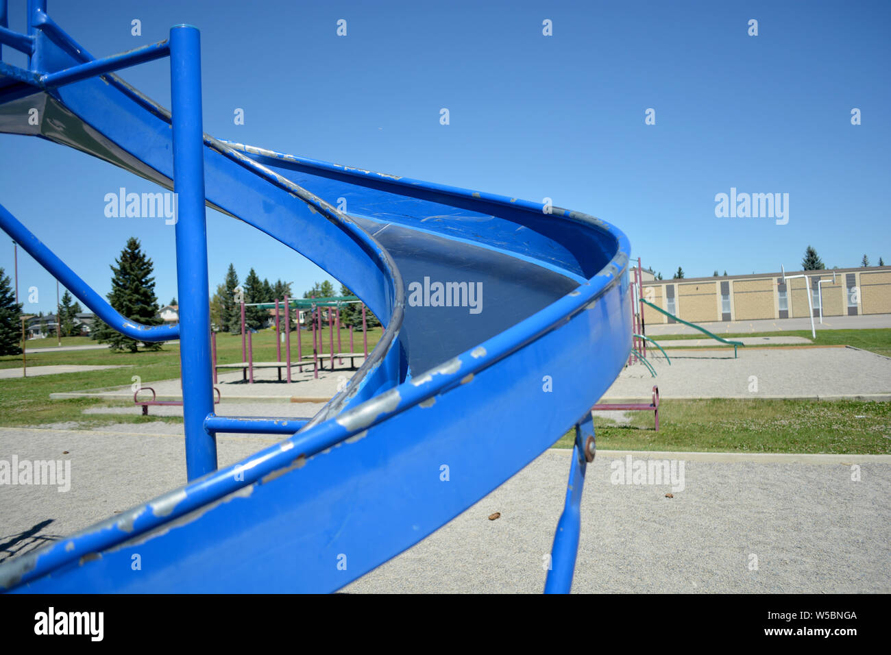 Colourful playground slide in school yard with school in background ...