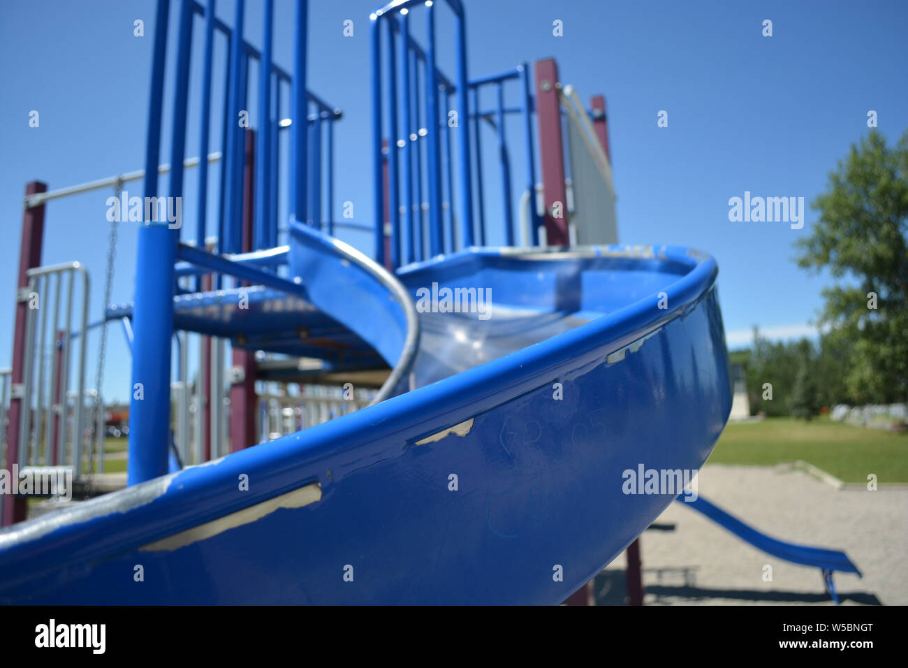 Colourful playground slide in school yard with school in background ...