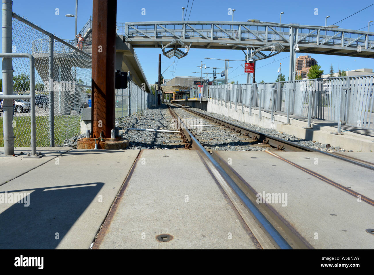 Pedestrian transit train track line at city station Stock Photo - Alamy