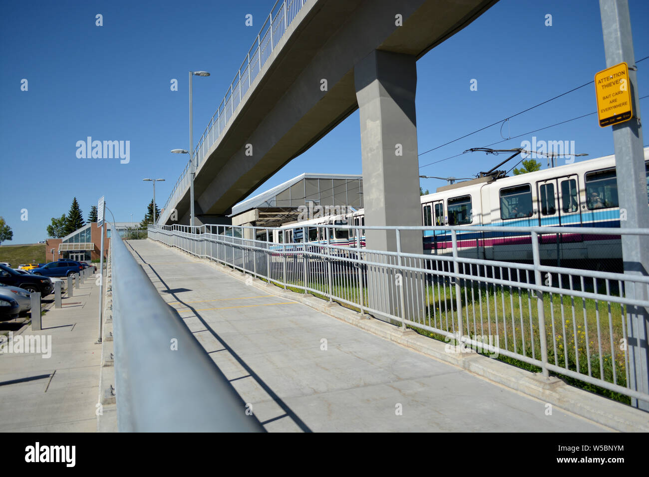 Pedestrian walkway by train track line at city station Stock Photo - Alamy
