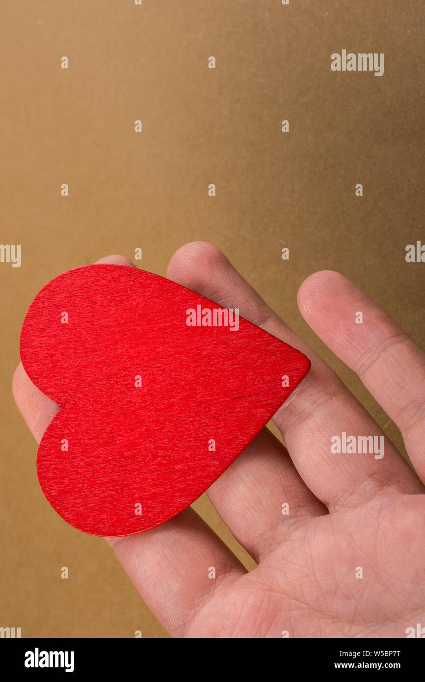Red color heart shaped object in hand on dotted paper Stock Photo - Alamy