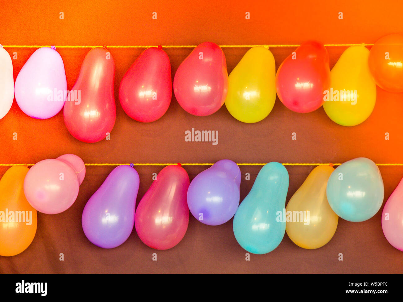 Balloon shooting game with balloons tied on a string Stock Photo - Alamy