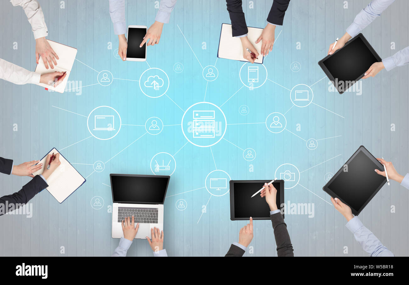 Group of people with devices in hands working in team on tablets ...