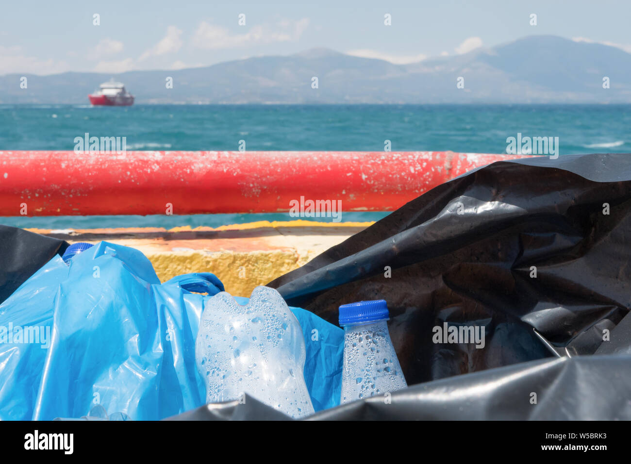Avoid plastic packaging. Garbage can full of garbage with sea, ocean on ...