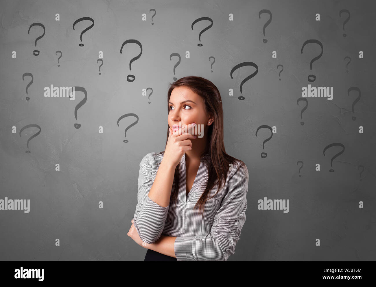 Person with question marks around face Stock Photo - Alamy
