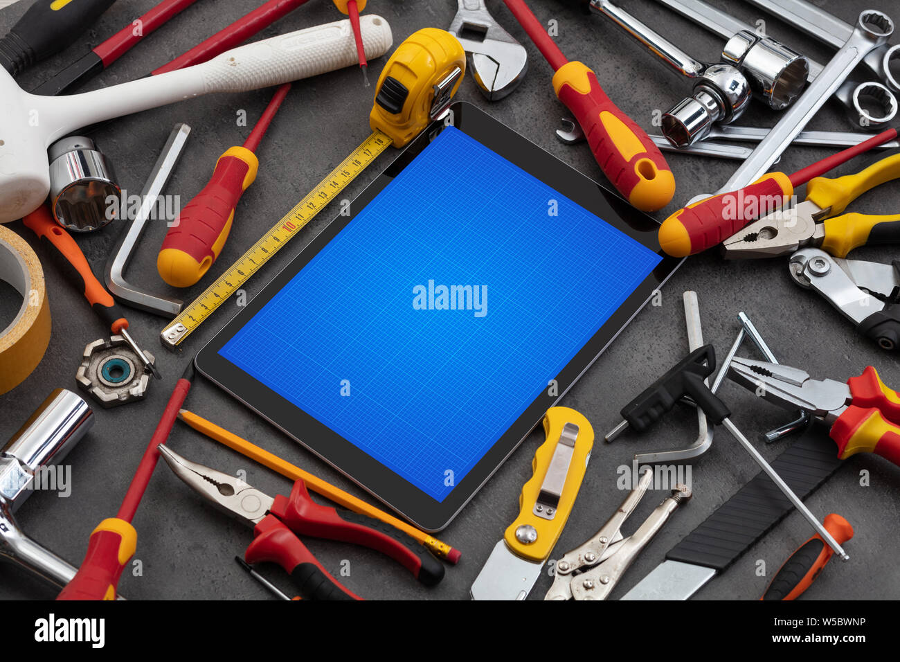 Household tools and tablet with grid screen concept Stock Photo - Alamy