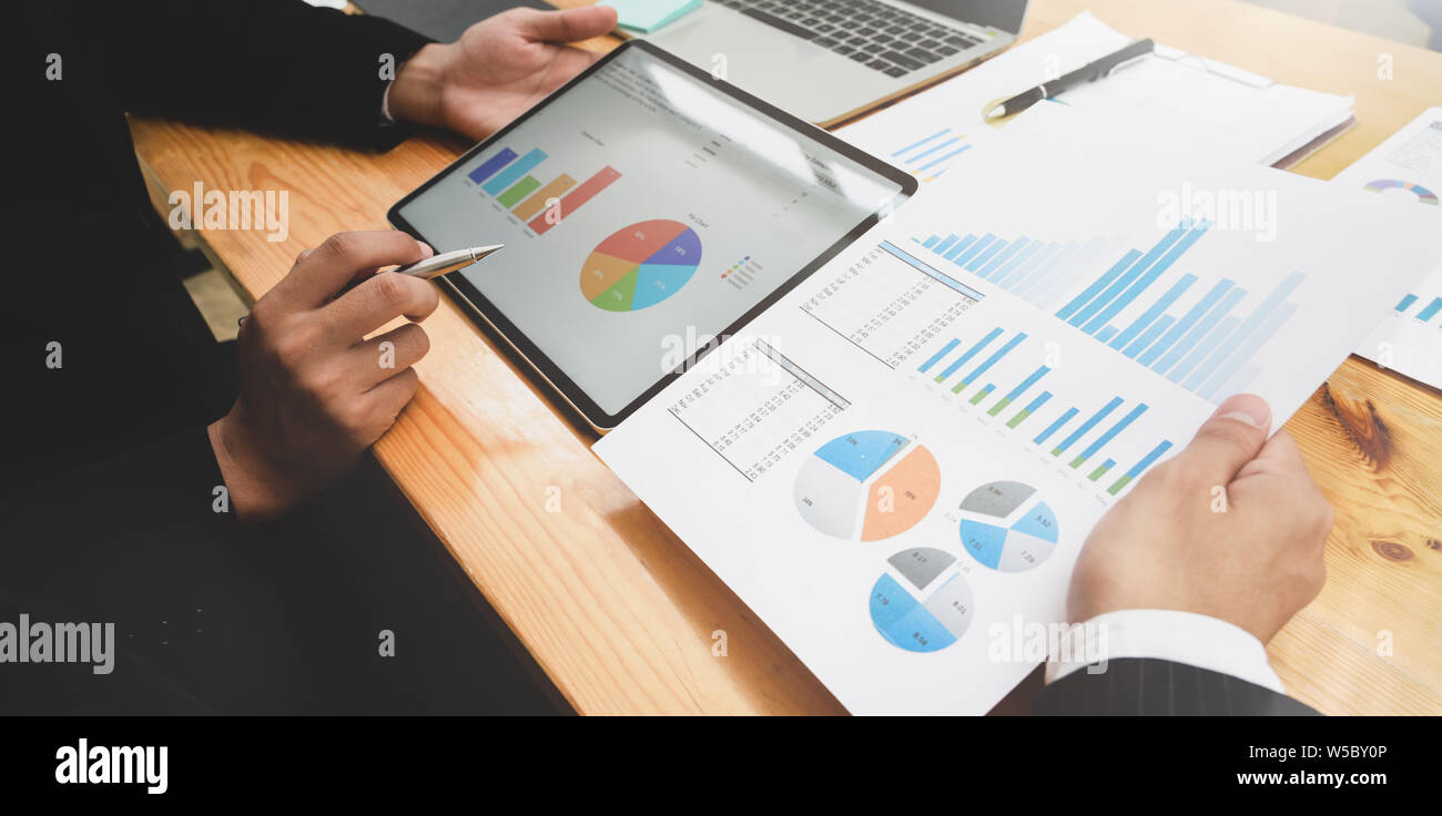 A group of business people discussing the statistics plan with charts ...