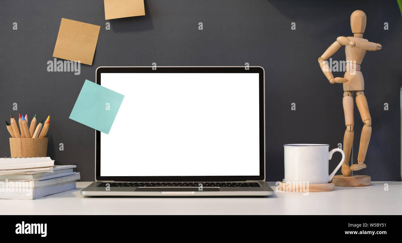 Open blank screen laptop in dark stylish work place with decorations ...