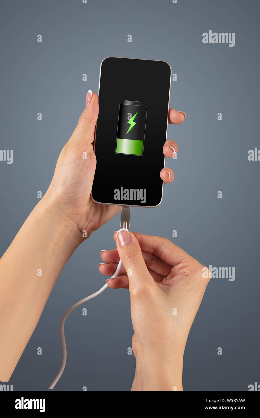 Elegant hand charging cellphone with low battery Stock Photo - Alamy