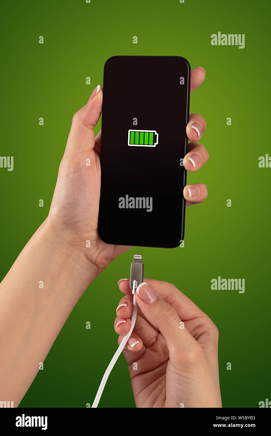 Elegant hand charging cellphone with low battery Stock Photo - Alamy