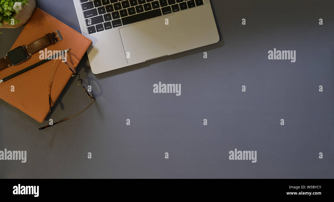 Designer's stylish dark work place with laptop and notebook, Top view ...