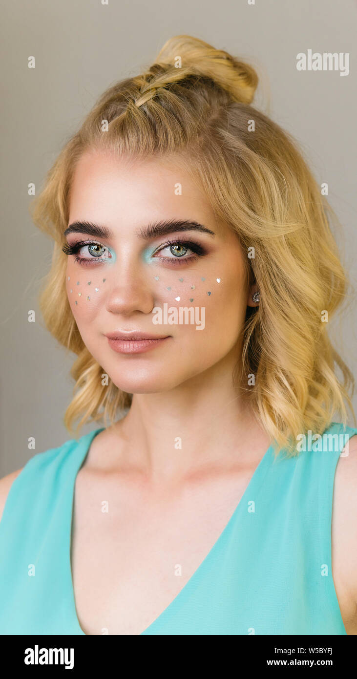 Portrait of cute girl with glitter on cheeks. Attractive charming woman ...