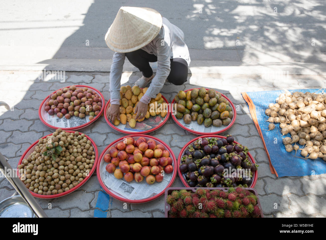 A woman arranging her fruit and vegetable produce for sale on the ...