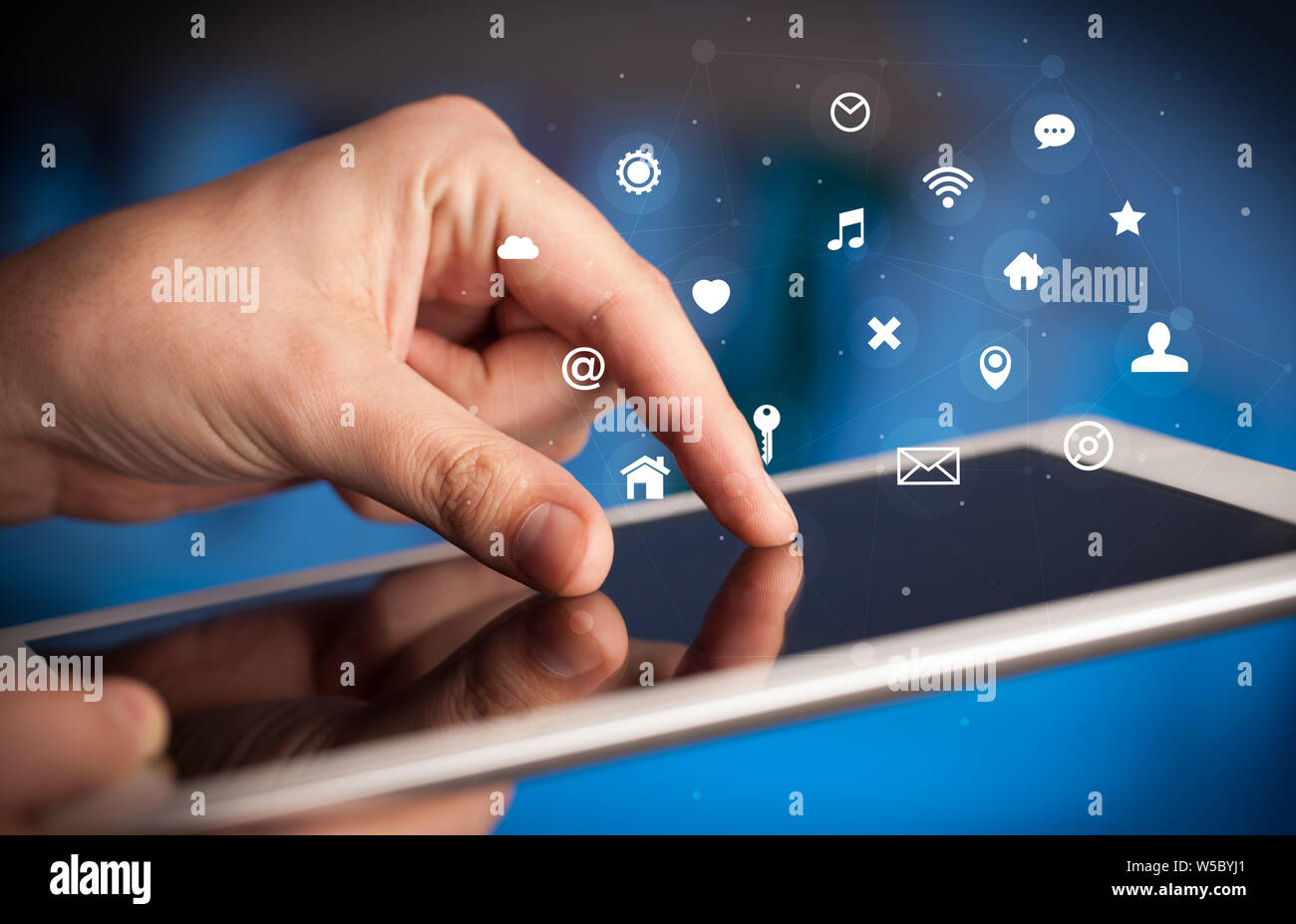 Hand holding tablet with multimedia and application symbols concept ...