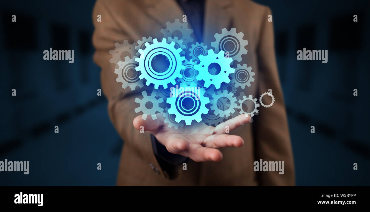 Hand holding gears in his hand Stock Photo - Alamy