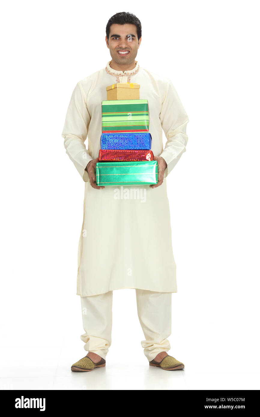 Man holding stack of gifts and smiling Stock Photo - Alamy