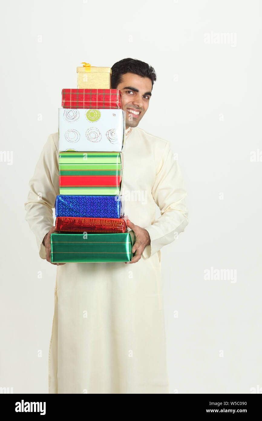 Man carrying gift boxes and smiling Stock Photo - Alamy
