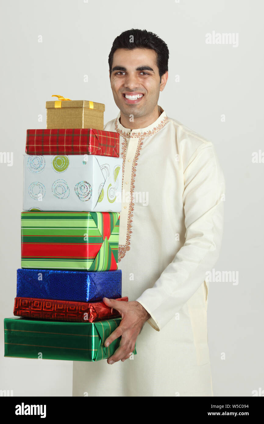 Man carrying gift boxes and smiling Stock Photo - Alamy