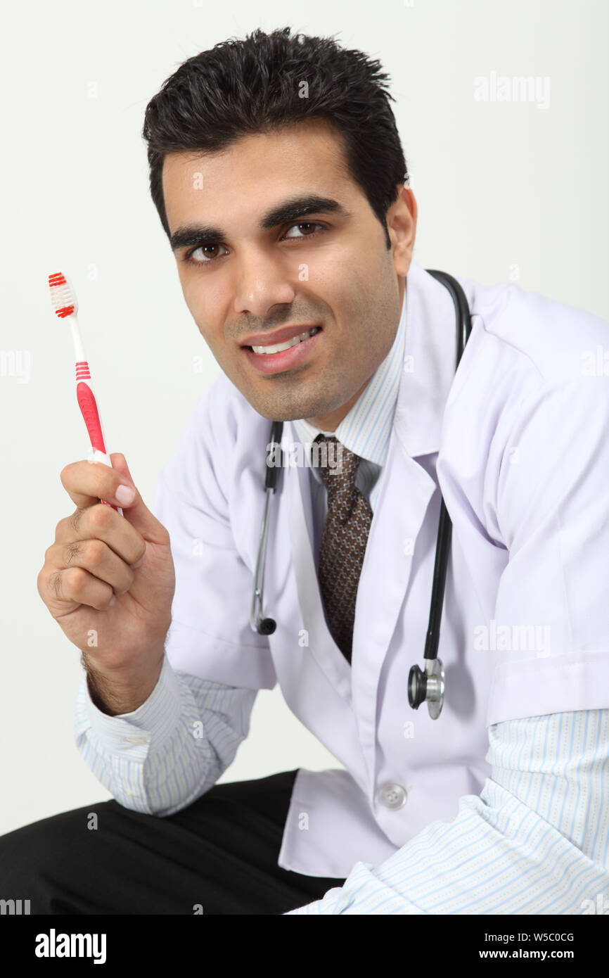 Dentist showing a toothbrush Stock Photo - Alamy
