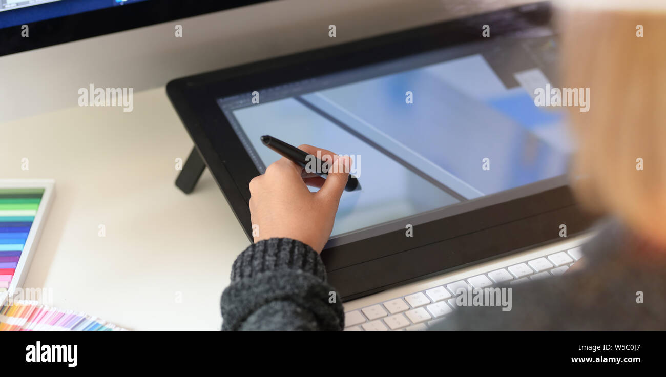 Female creative designer using a graphic tablet screen and stylus ...