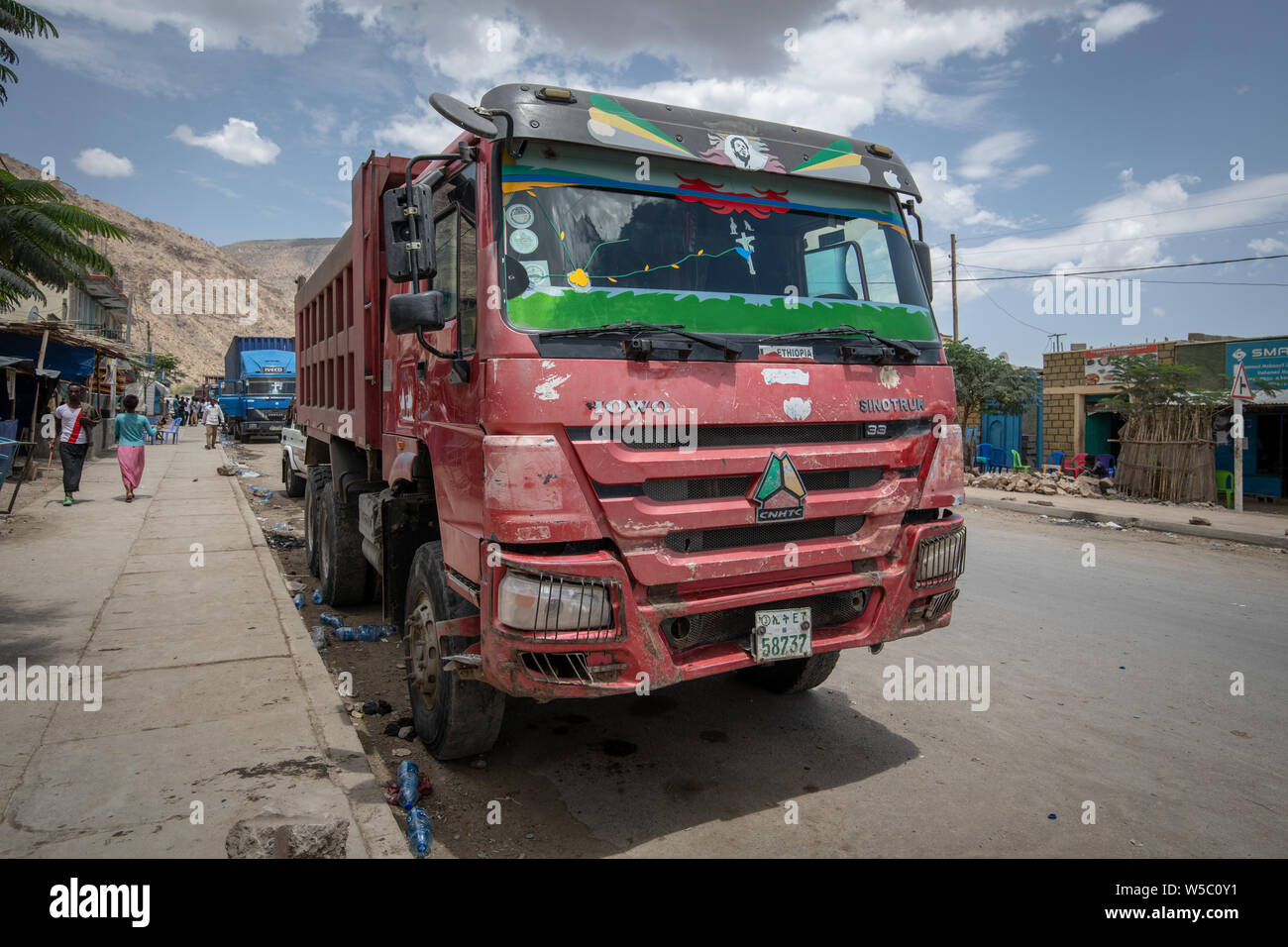 A beat up red truck parked on the side of a street, Danakil Depression ...