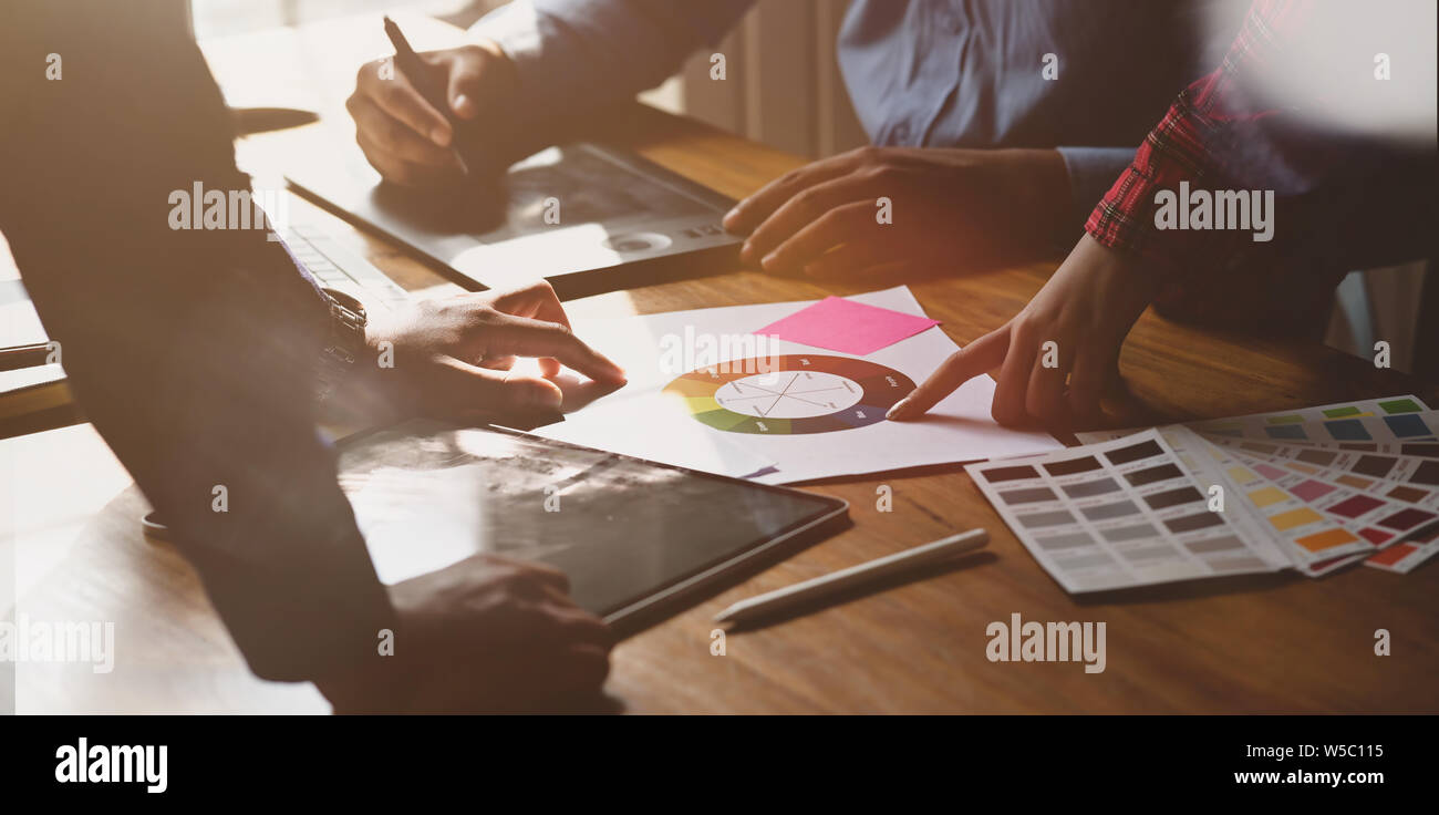 Creative designer team meeting discussion ideas on desk Stock Photo - Alamy