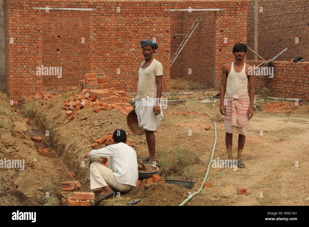 Mason with labour working at a construction site, Haryana, India Stock ...