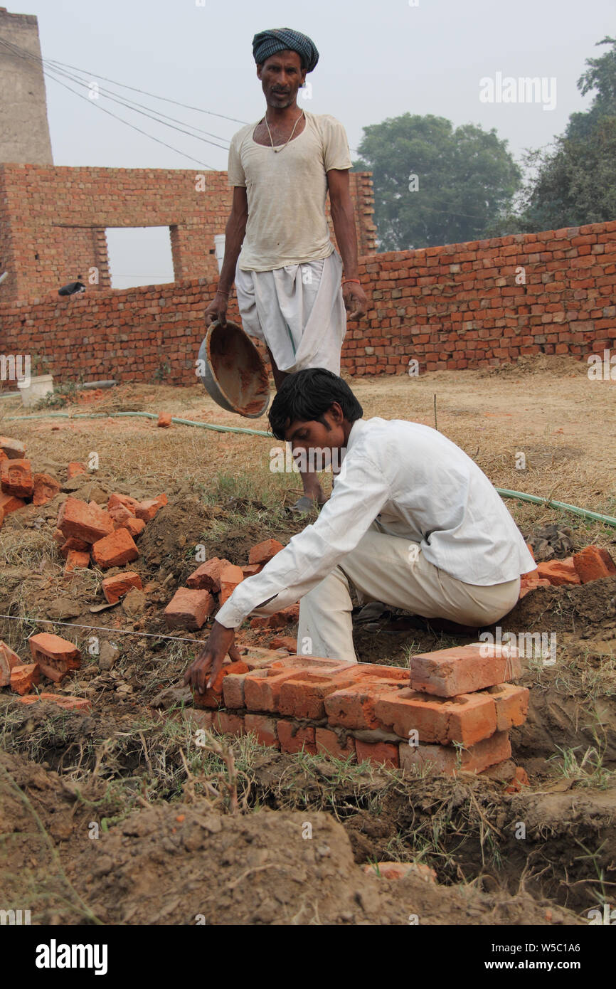 Mason with labour working at a construction site, Haryana, India Stock ...