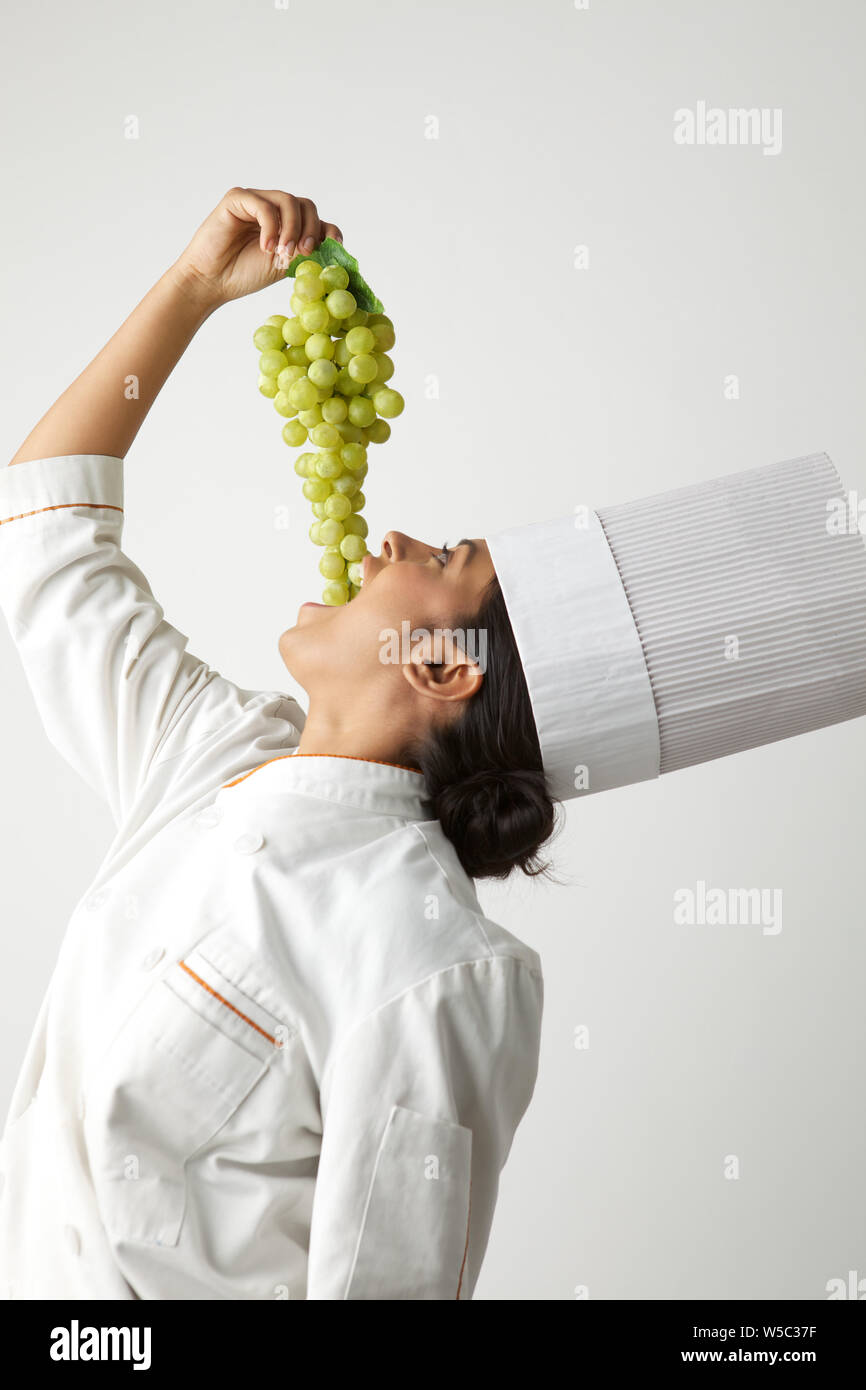 Chef eating bunch of grapes Stock Photo - Alamy