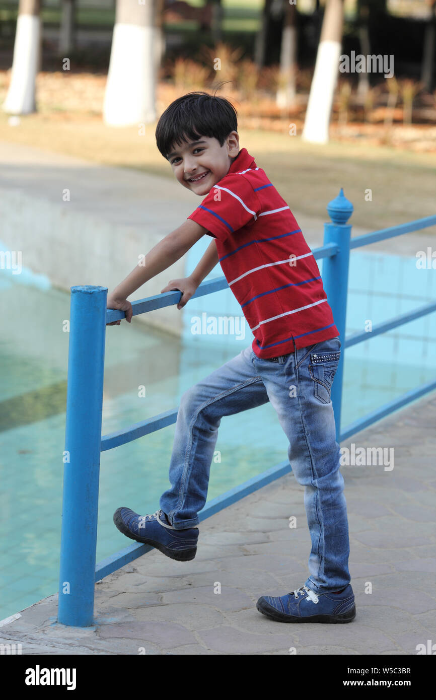 Boy leaning at railing and smiling Stock Photo - Alamy