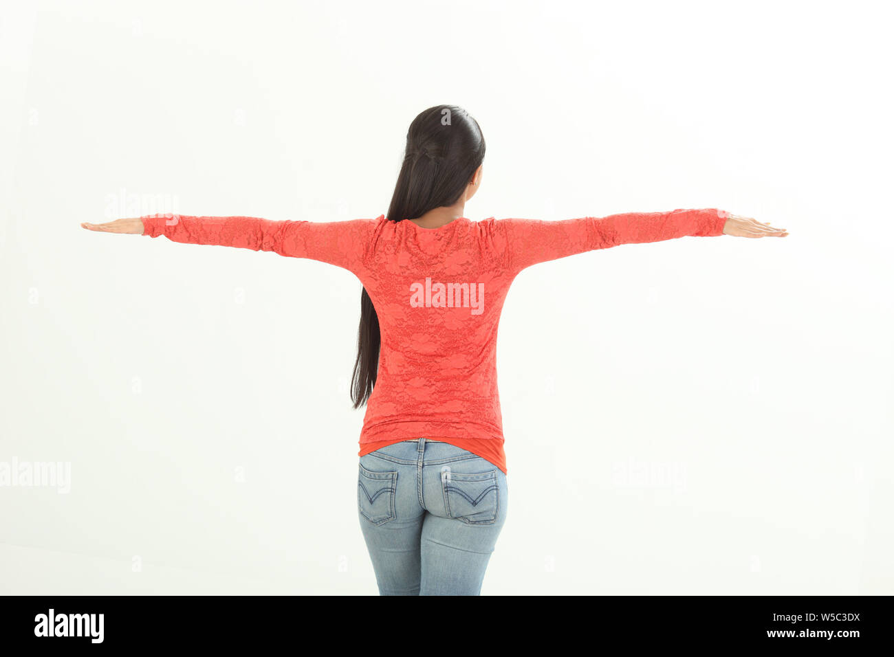 Rear view of an Indian woman standing with her arm outstretched Stock ...