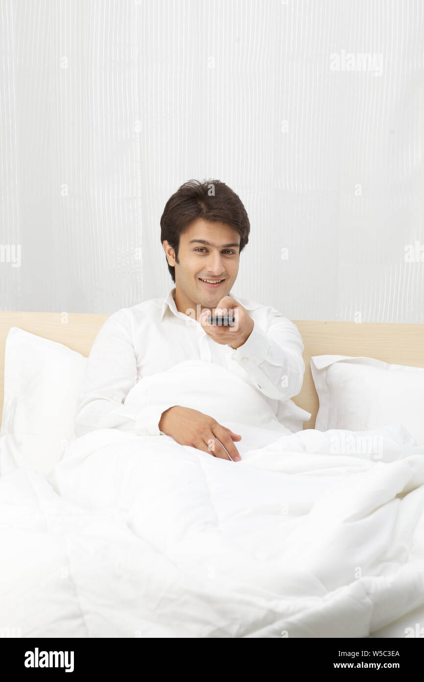 Man watching TV and smiling Stock Photo - Alamy