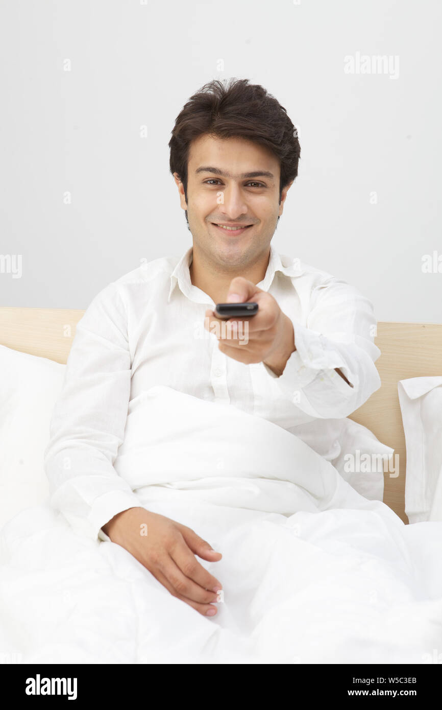 Man watching TV and smiling Stock Photo - Alamy
