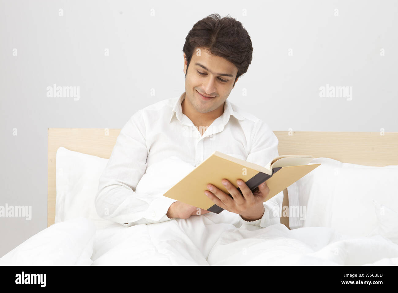 Indian man book reading reclining hi-res stock photography and images ...