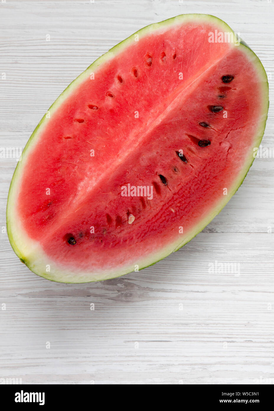 Fresh cut watermelon on a white wooden background, overhead view. Flat ...