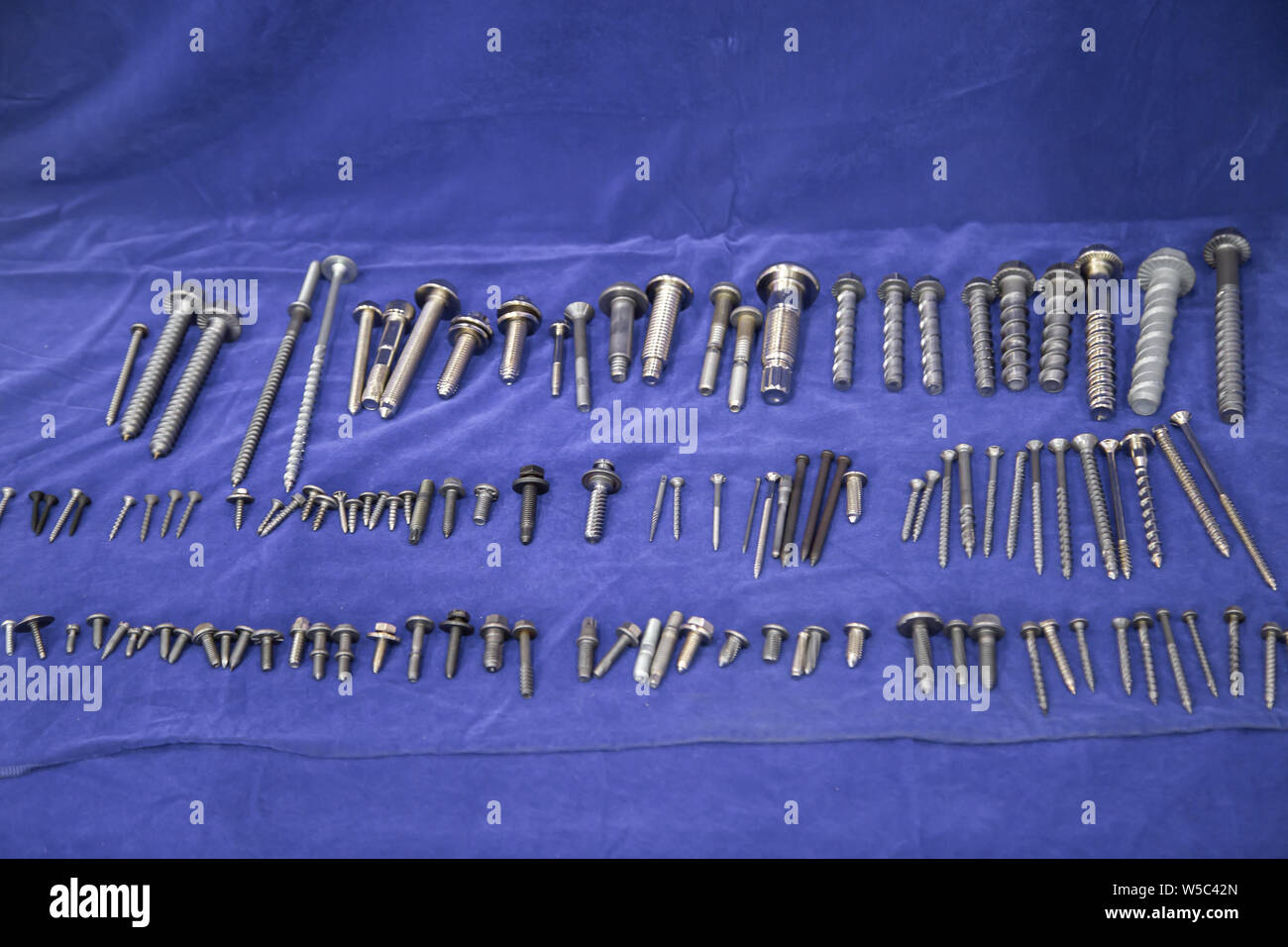 Different type and size of screws on blue fabric background Stock Photo ...