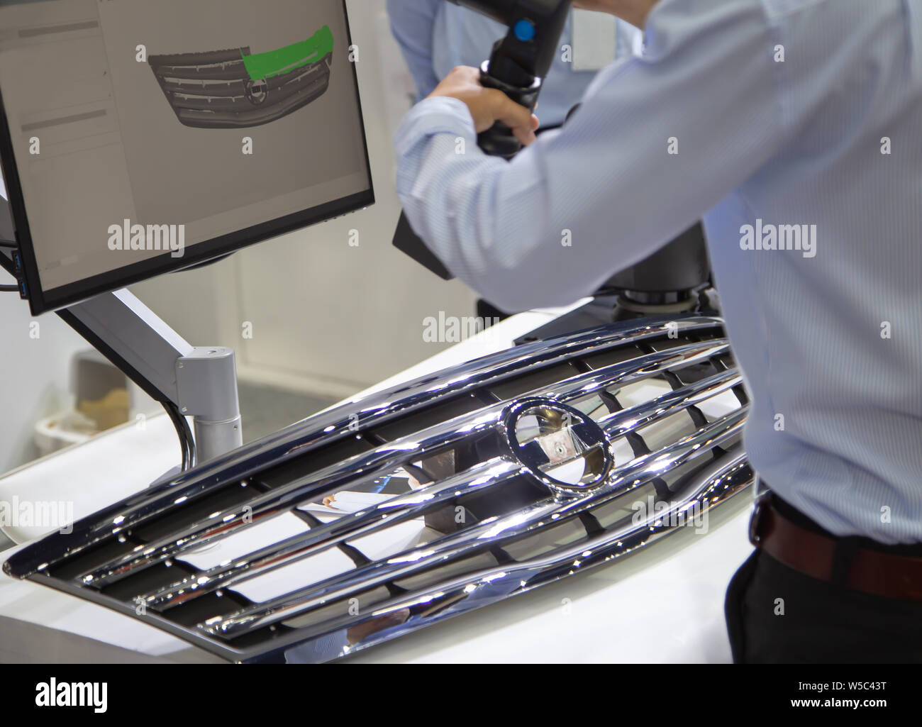 Industry worker use handheld 3D scanner inspecting car grille Stock ...