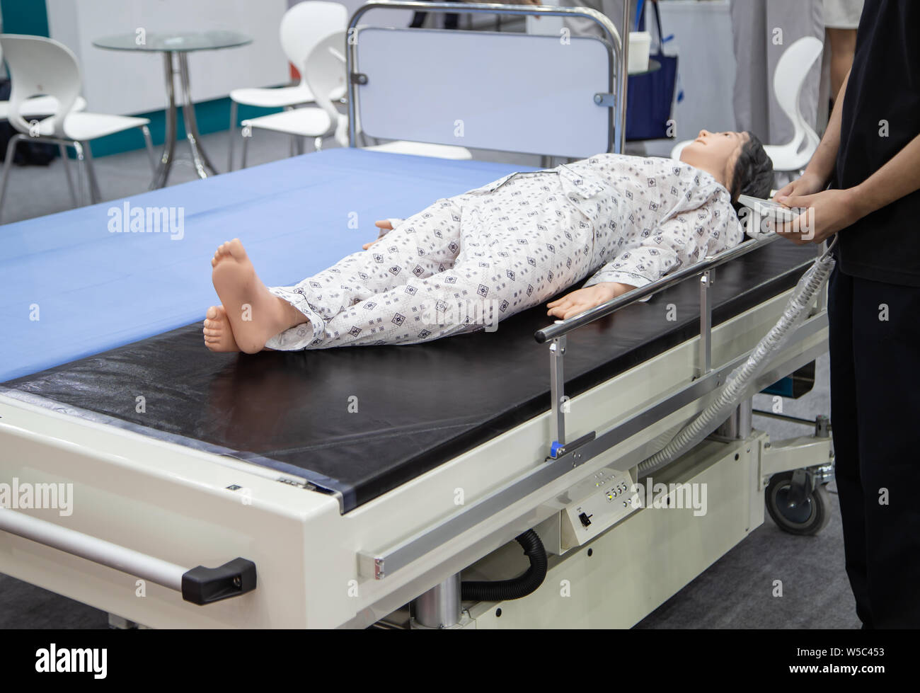 Patient dummy lying on mobile hospital bed while medic adjusting Stock ...