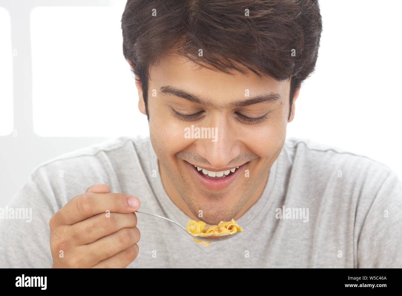 Young man eating cornflakes hi-res stock photography and images - Alamy