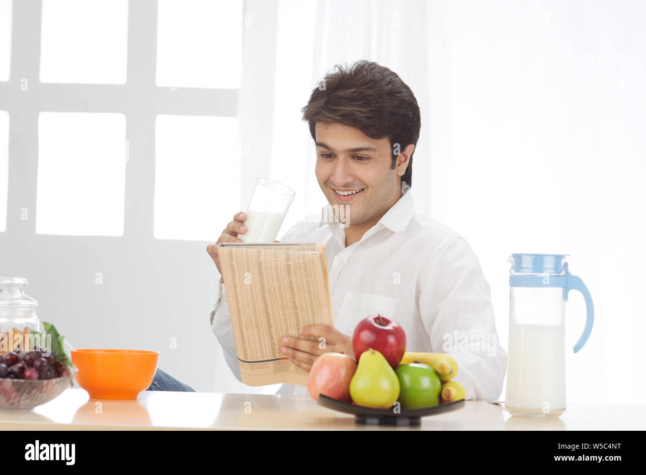 Man having breakfast and reading newspaper Stock Photo - Alamy