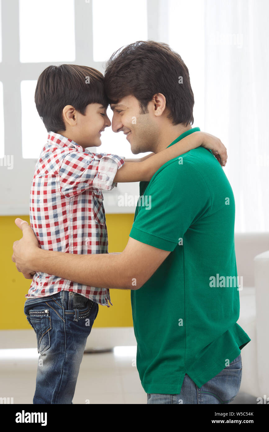 Man hugging his son and smiling Stock Photo - Alamy